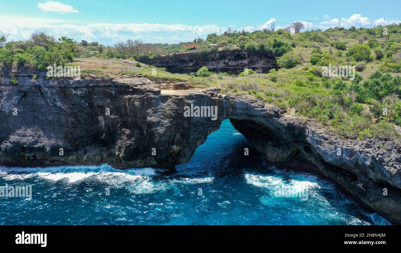 View on rock arch over ocean in Nusa Penida, Broken Beach, Indonesia ...