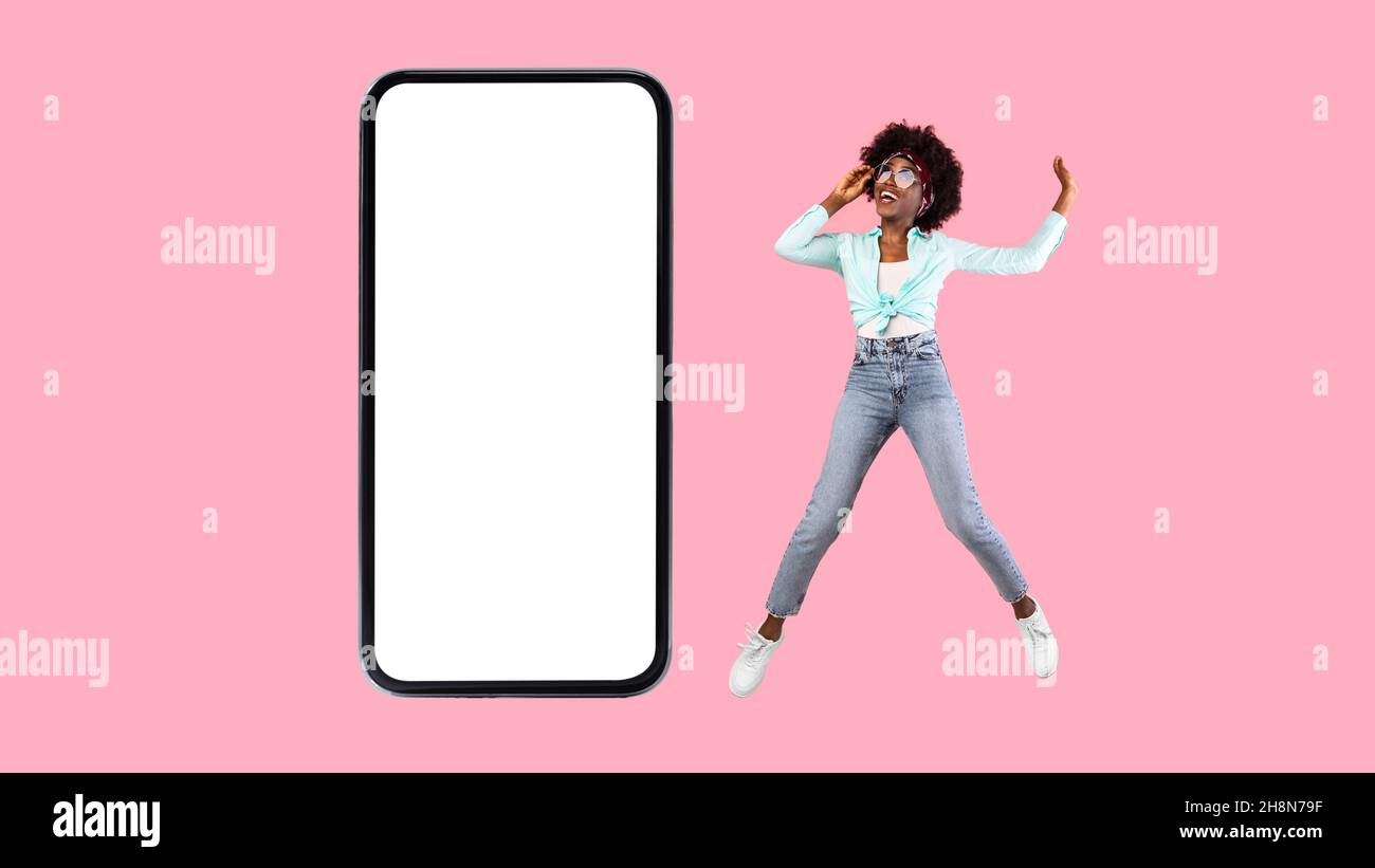 Happy woman showing white empty smartphone screen and jumping Stock ...