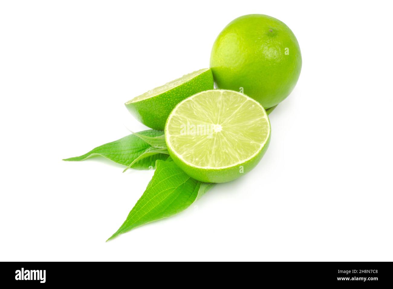 Two halves and whole lime isolated on white background with leaves ...