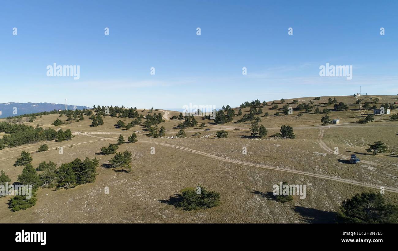 Top view of field with rural road and car. Shot. Panoramic view of blue ...