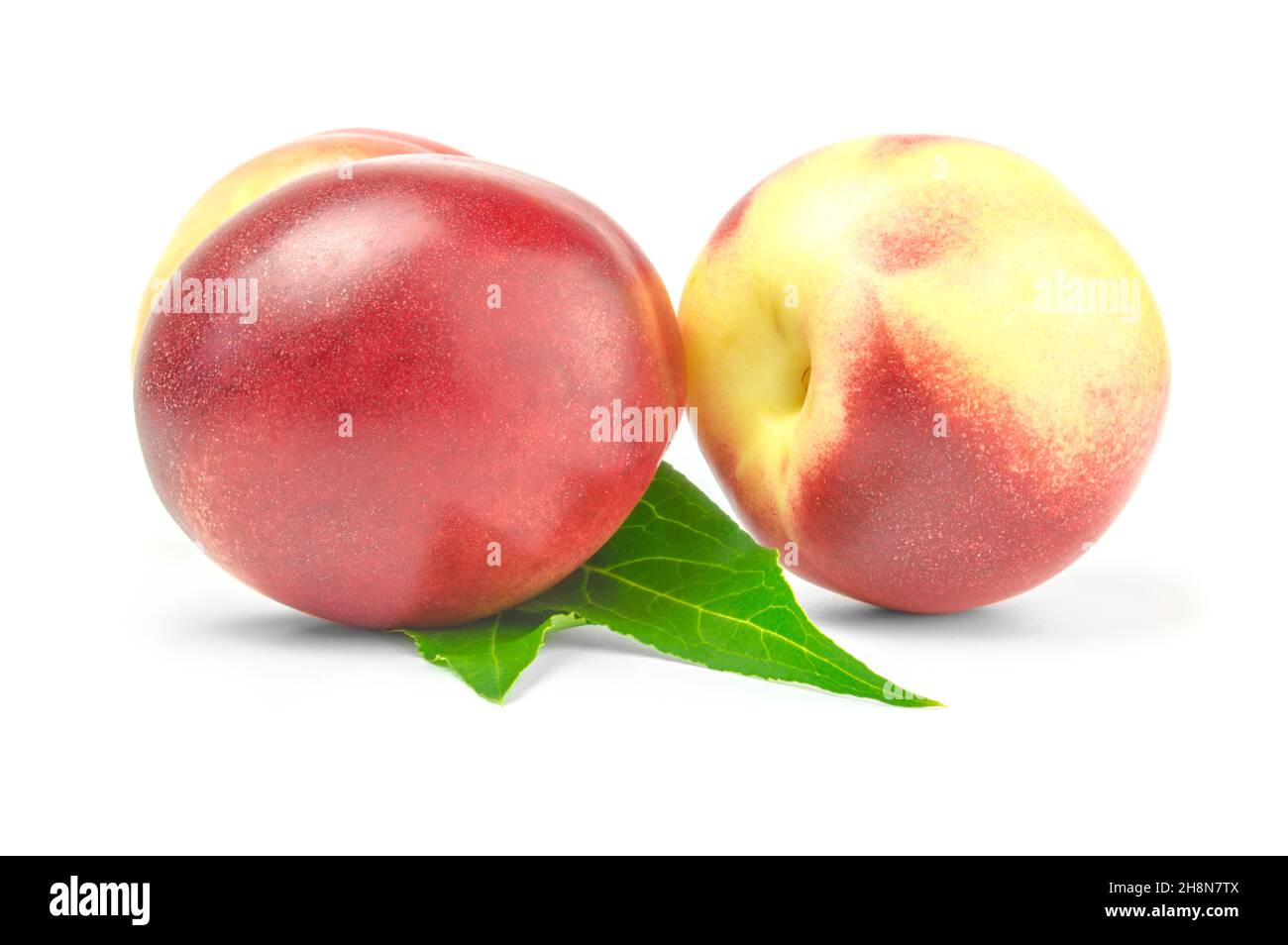 Two ripe nectarines with green leaves over white background Stock Photo ...
