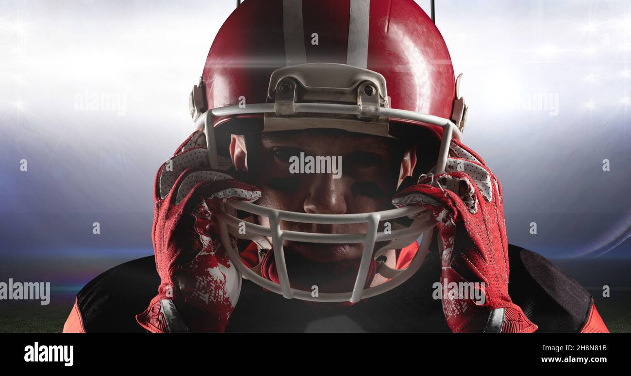 Portrait of confident male american footballer adjusting helmet at ...