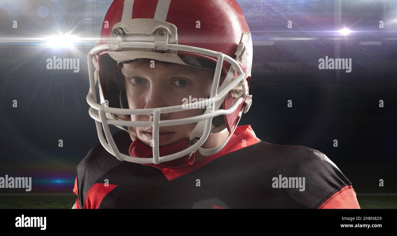 Portrait of young male american footballer wearing red helmet at ...