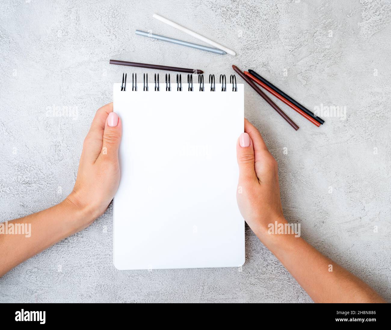 Girl's hands holding notebook Stock Photo - Alamy