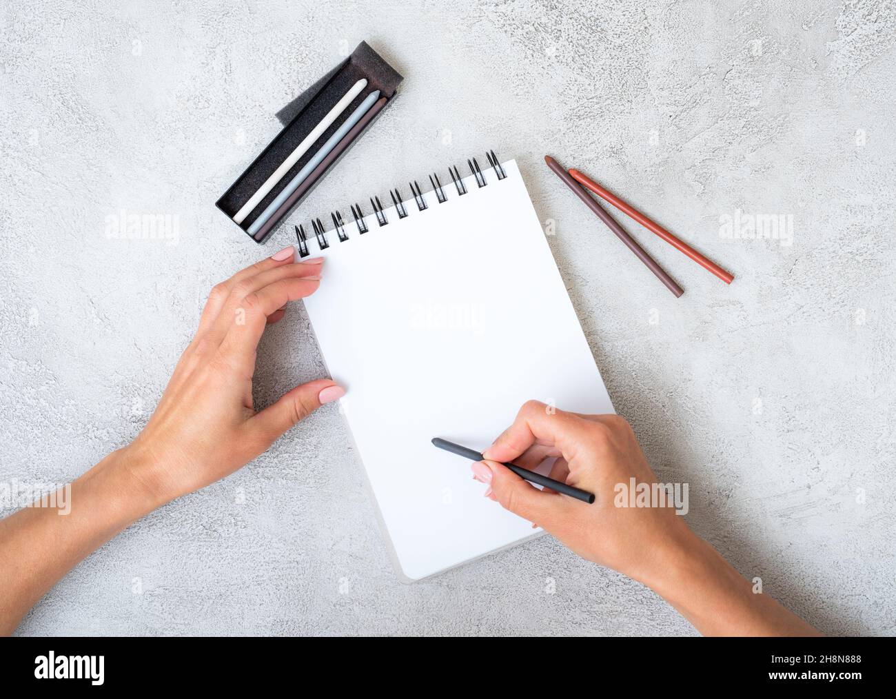 Girl's hands drawing in notebook Stock Photo - Alamy