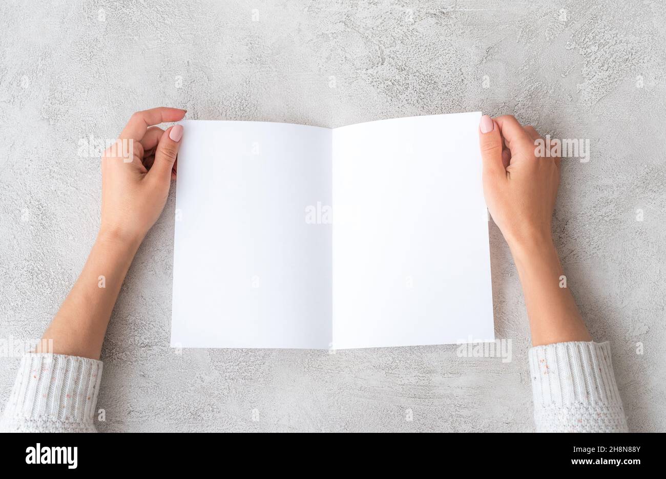 Girl' hands holding sheet of paper Stock Photo - Alamy