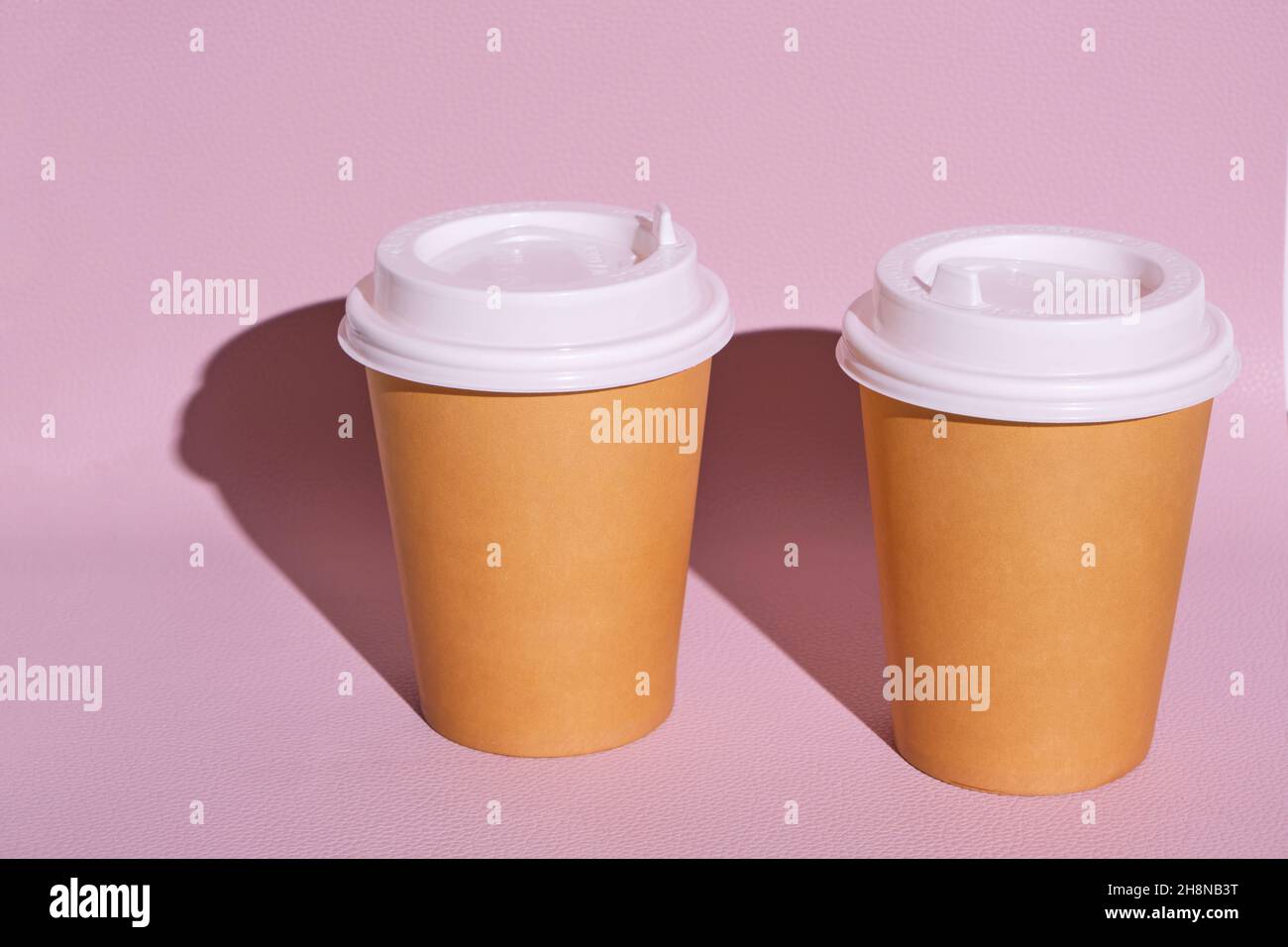 Disposable cups for hot coffee or tea on a pink background in the ...