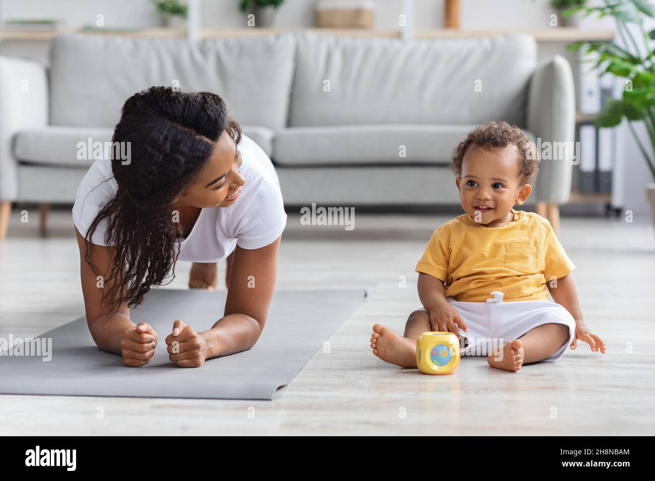 Sport At Home. Young Black Mom Making Plank Exercise With Little Baby ...