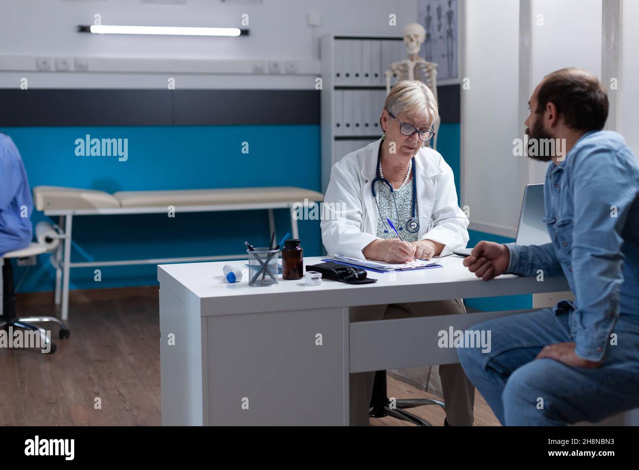 Woman doctor signing checkup files to give treatment to man after ...