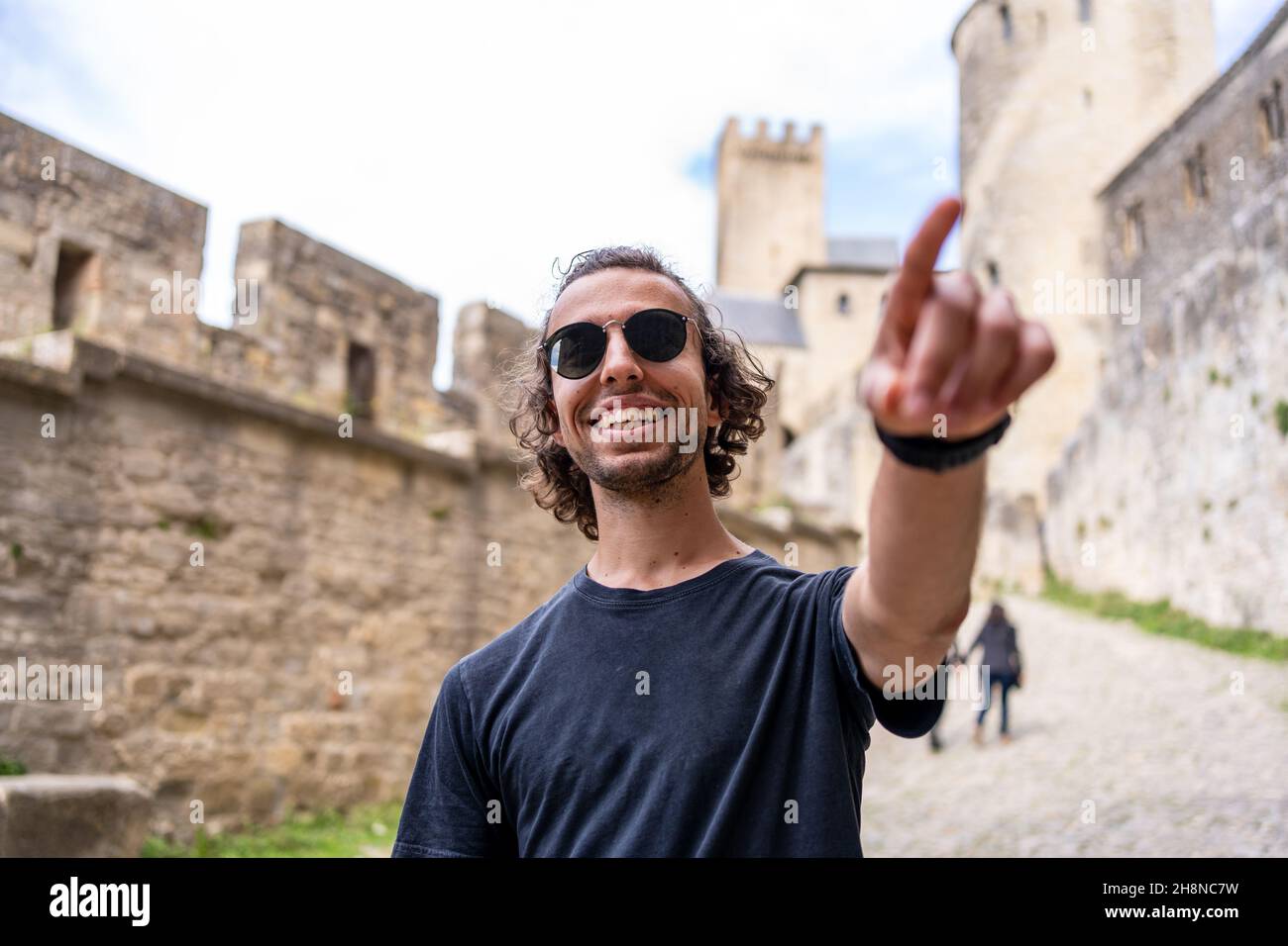 Photo with selective focus on a smiling man pointing forward in a ...