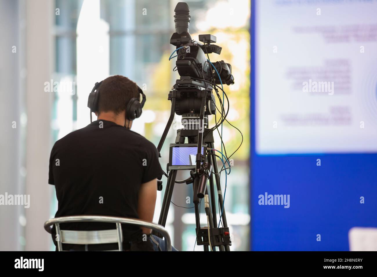 Camcorder Operator filming Live Show sitting on a Chair Stock Photo - Alamy