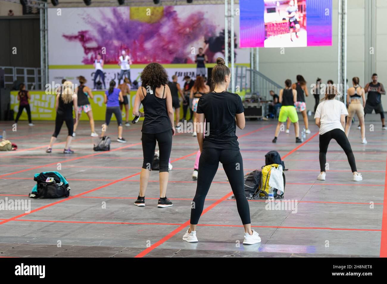 Fitness Workout in Gym: People doing Exercises in Class with Music and ...