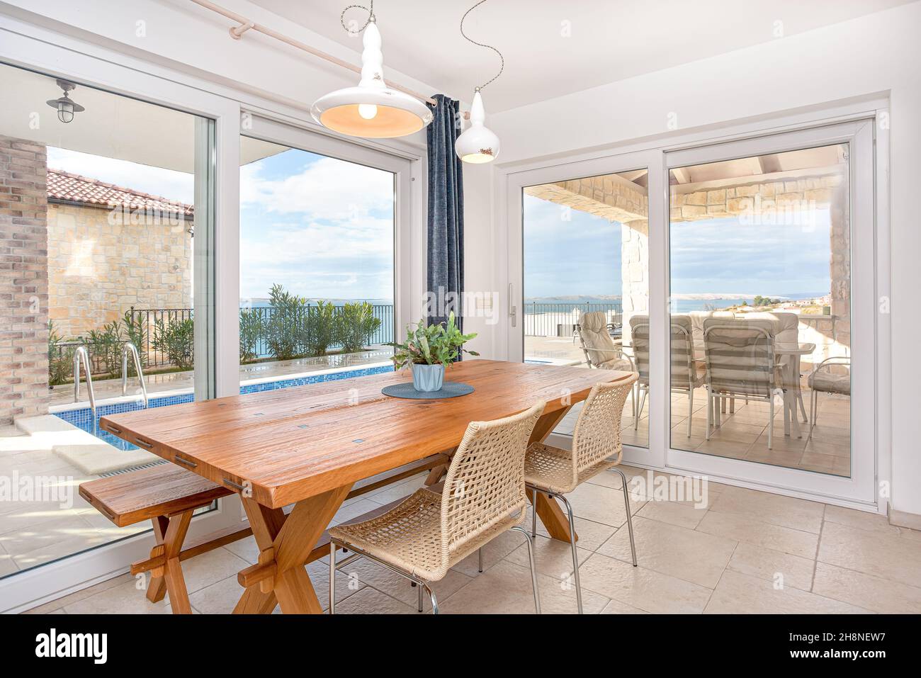Dining room with panoramic windows with seaside view and heated pool ...