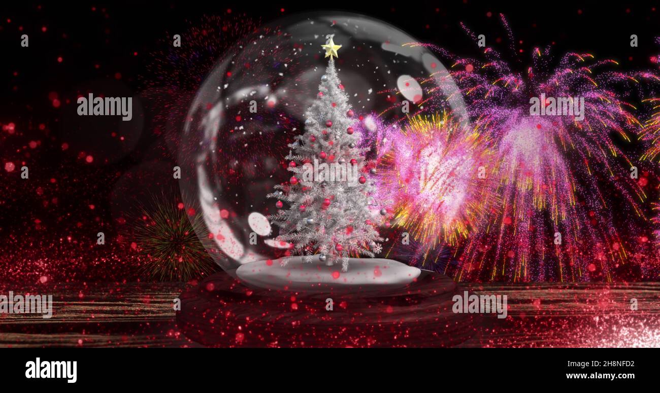 Image of decorated christmas tree in snow globe and colourful fireworks ...