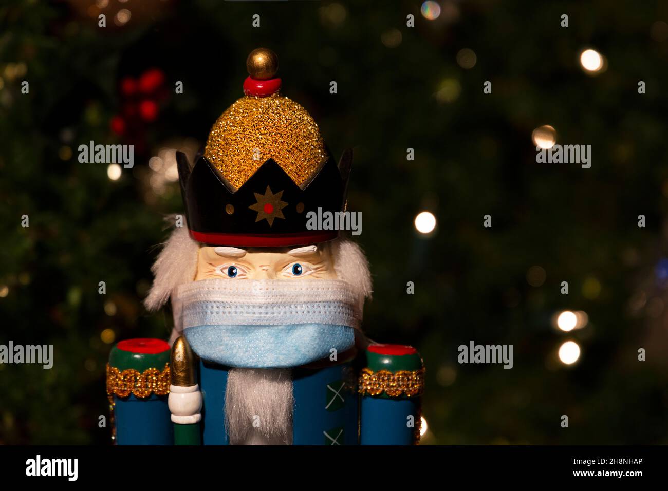Nutcracker wearing a mask in front of a Christmas tree Stock Photo - Alamy