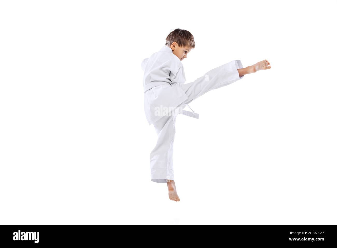 Full-length back view portrait of little boy, sportsman practising ...