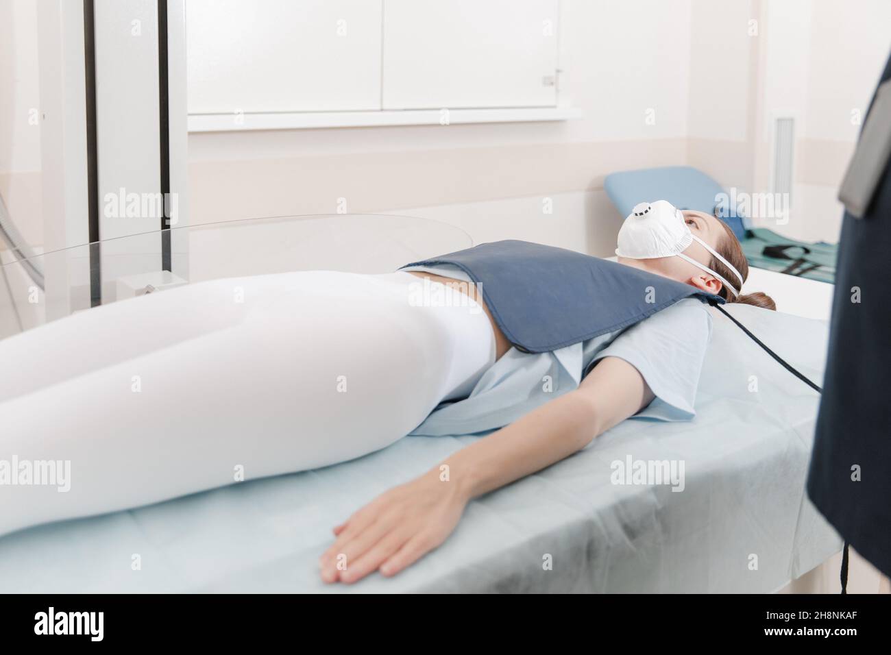 Doctor taking x-ray of patient lying on gurney. Hospital radiology room ...