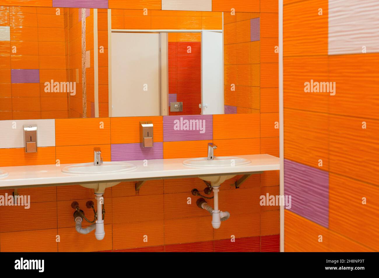 Creative men toilet in bright orange colors in mall Stock Photo - Alamy