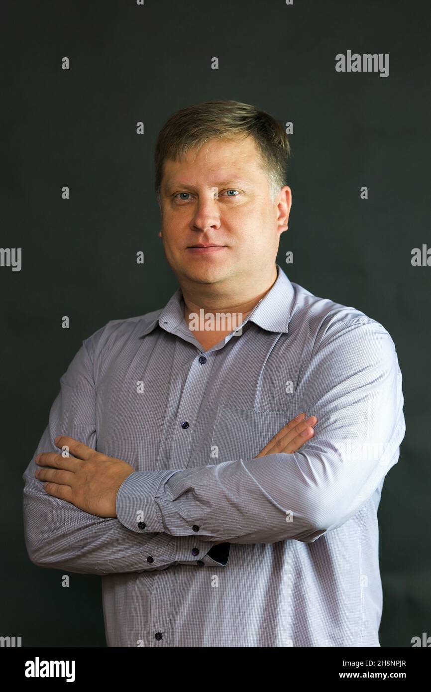 An adult Caucasian man of Slavic appearance in a blue shirt on a black ...