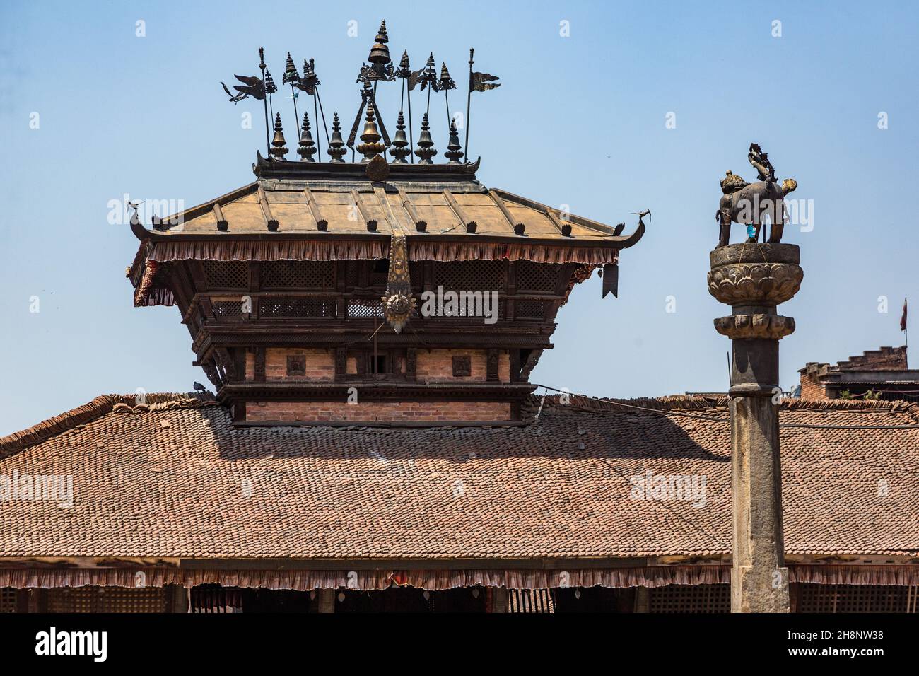 A Hindu guardian lion on a pedestal faces the Bhimsen Temple ...