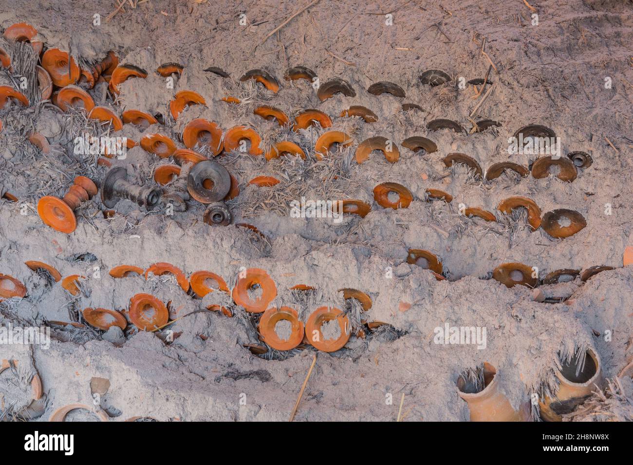 Ceramic pots cooling in ashes after being fired in a kiln in the ...