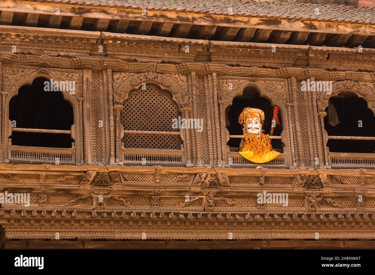 Mannequin figure of a Hindu priest in an intricately-carved window in ...