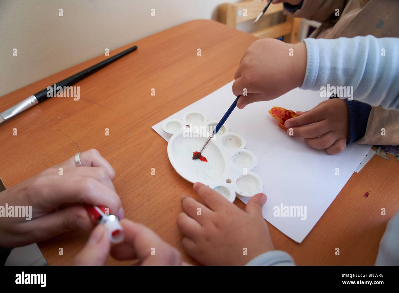 Child's hands pulling paint from palette. Preschool and family Stock ...