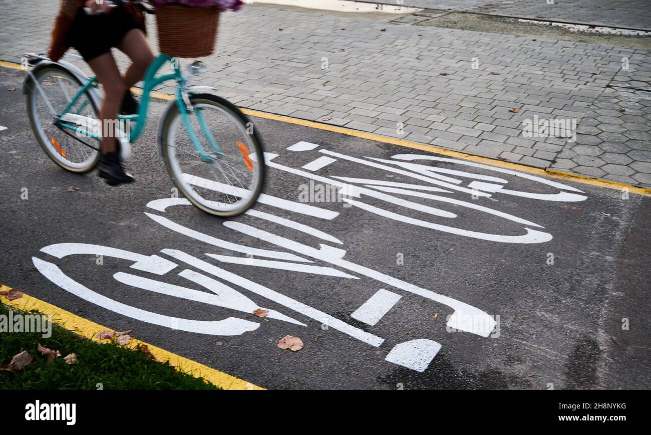 Side view of female riding vintage bicycle with big basket on ...