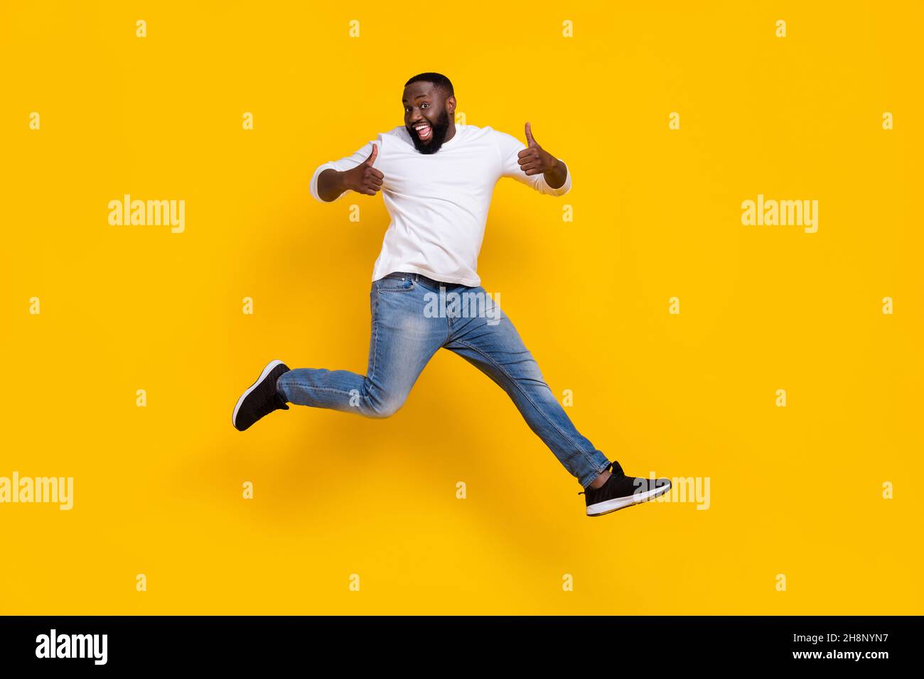 Full size photo of carefree overjoyed handsome guy jumping show thumbs ...