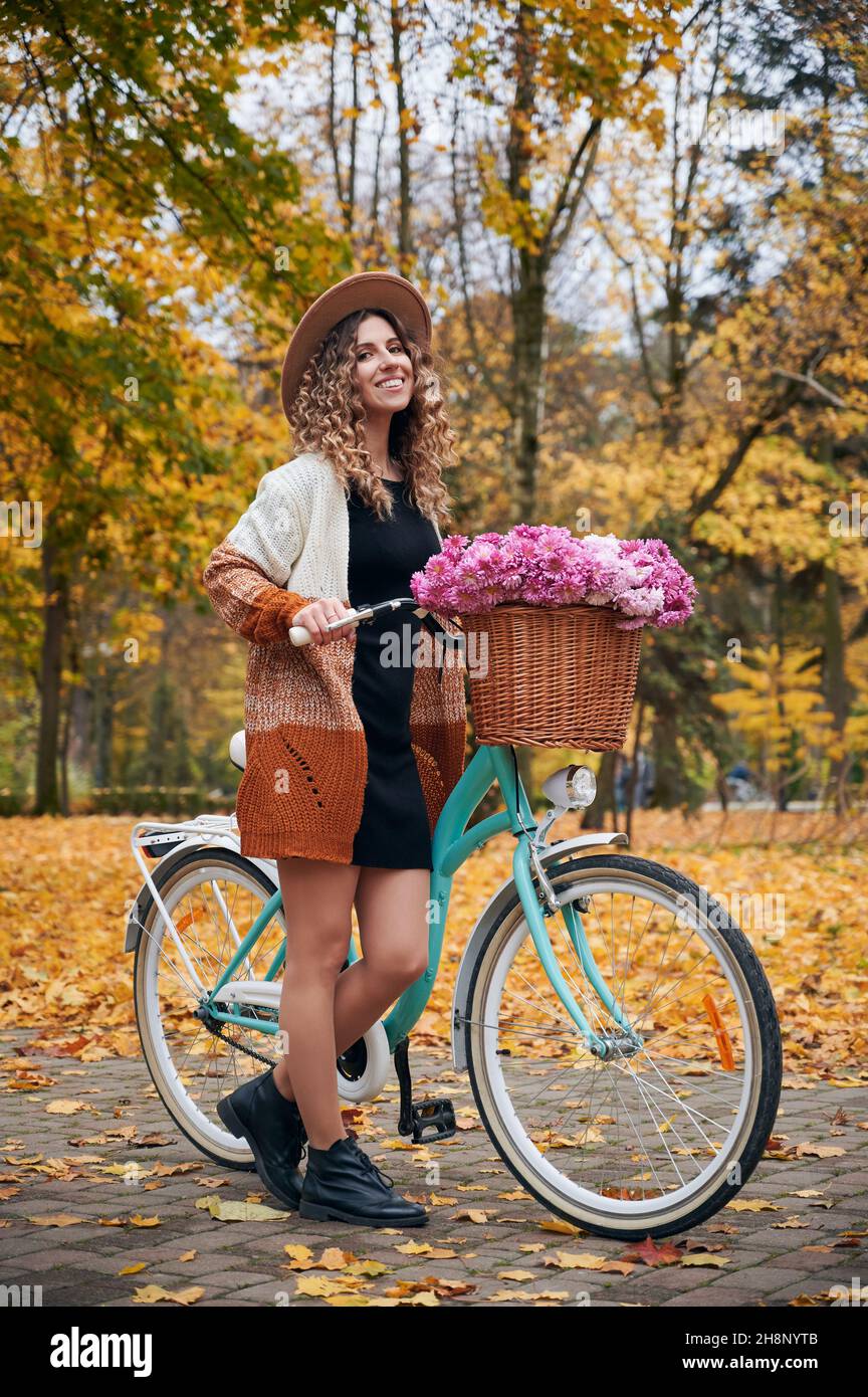 Pleasant bike ride along alleys of autumn park. Female beautiful ...