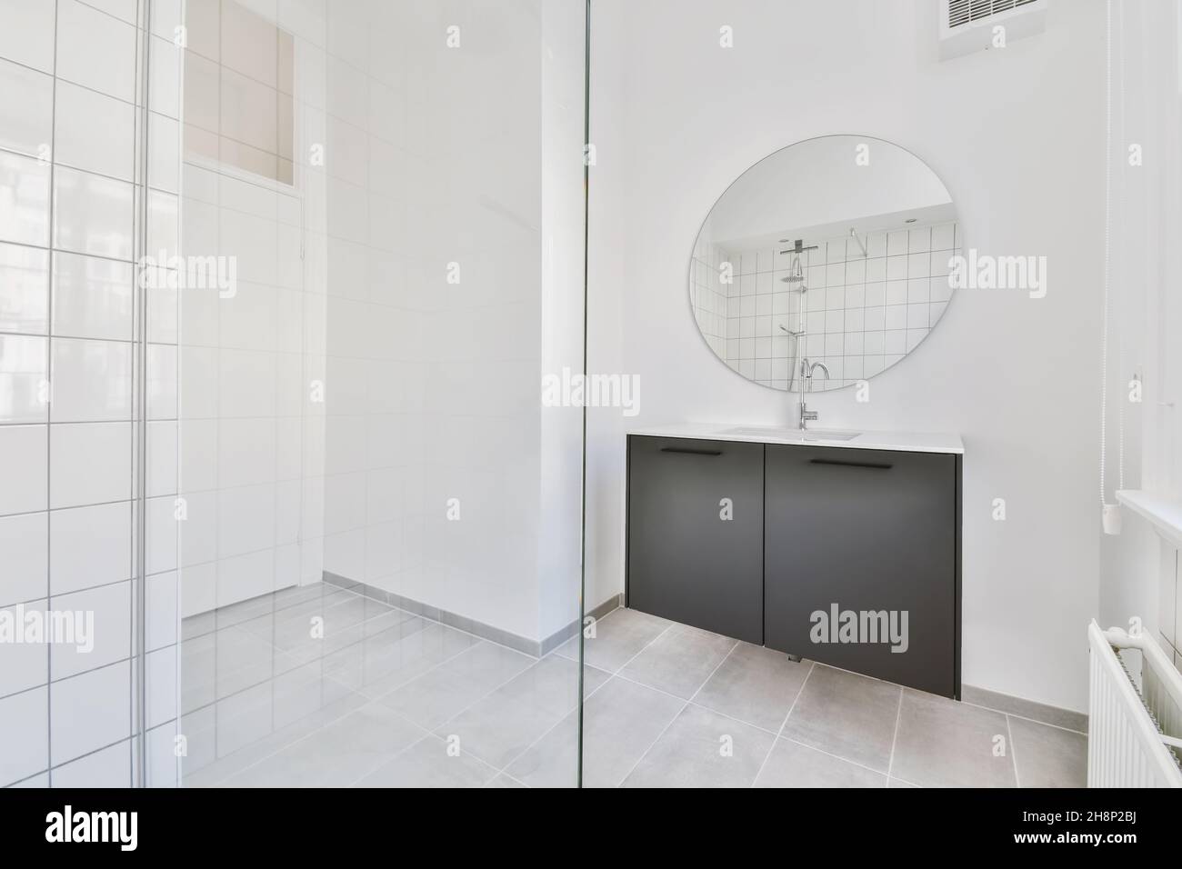 Delightful sink with faucet in front of round mirror Stock Photo - Alamy