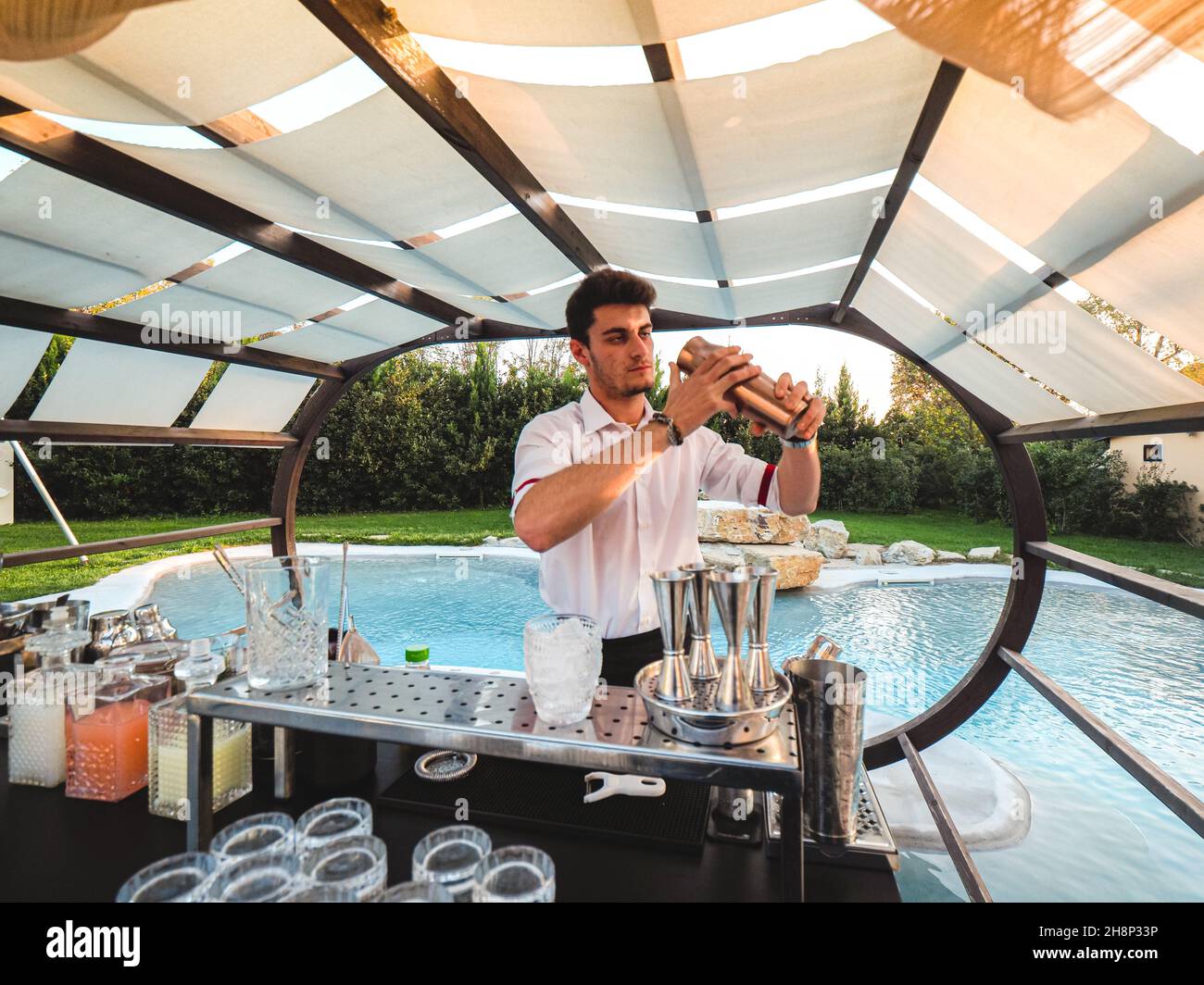 Bartender preparing cocktails near an outdoor pool venue location Stock ...