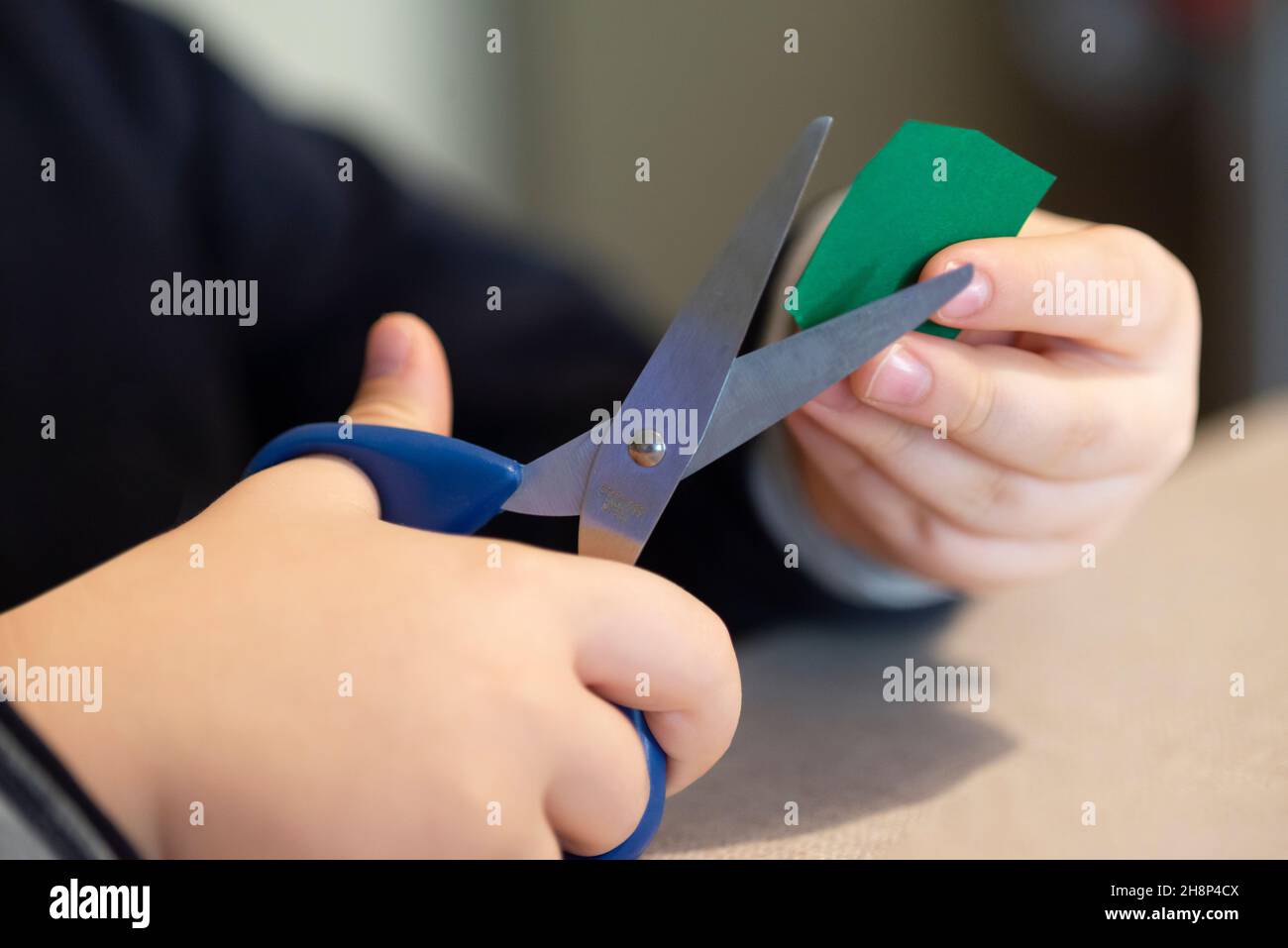 Boy Cuts out Figure with Scissors Stock Photo - Alamy
