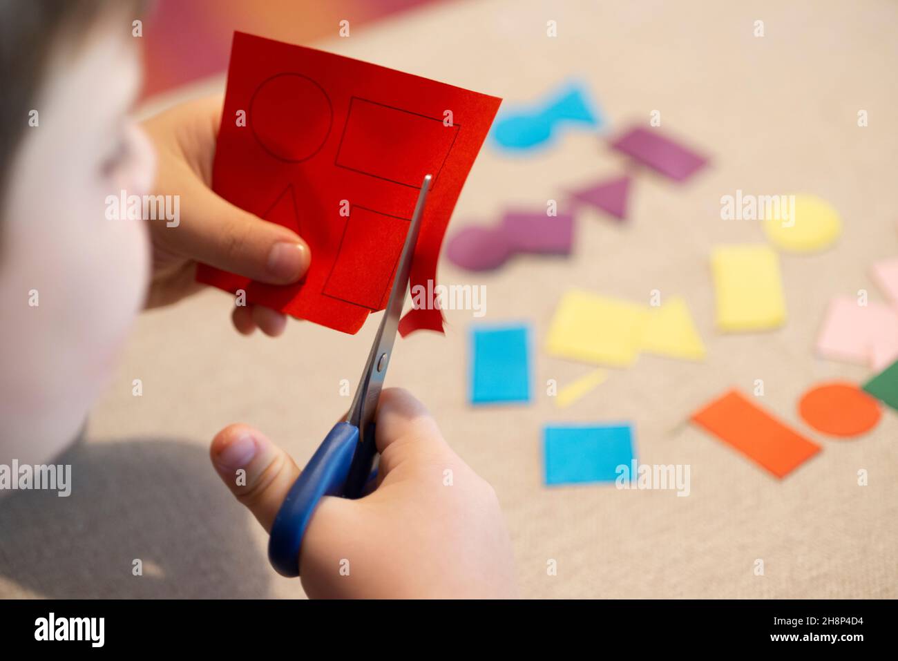 Boy Cuts out Figure with Scissors Stock Photo - Alamy
