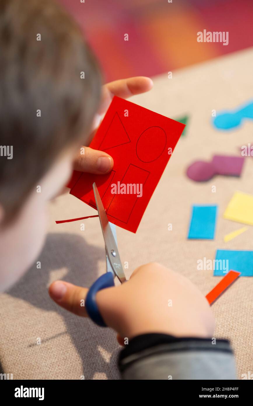 Boy Cuts out Figure with Scissors Stock Photo - Alamy
