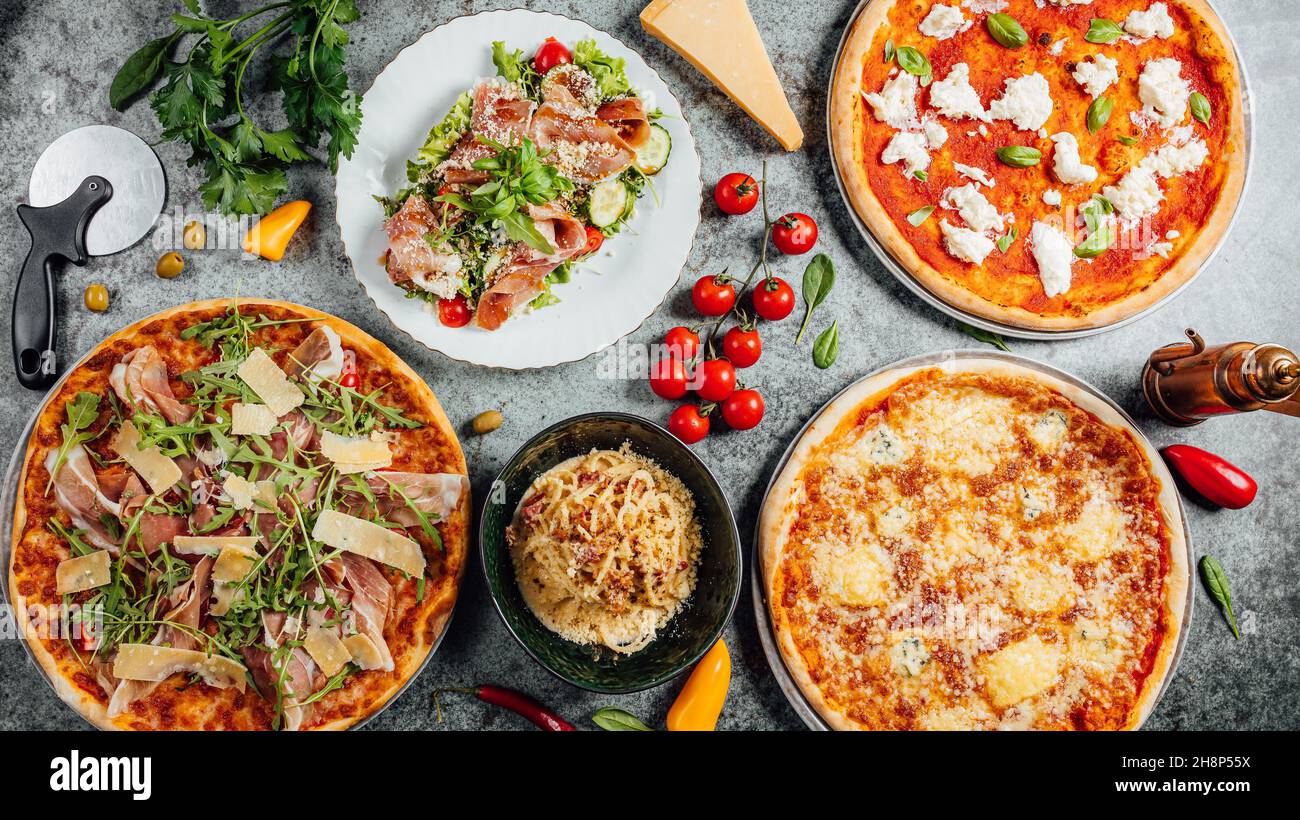 Top view of different types of pizza with pasta and vegetables on a ...