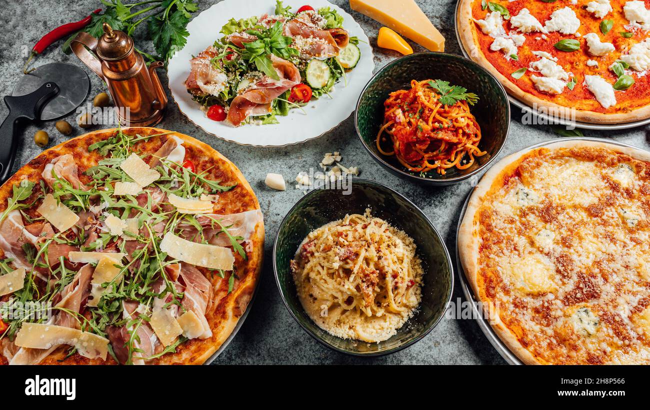 Top view of different types of pizza with pasta and vegetables on a ...