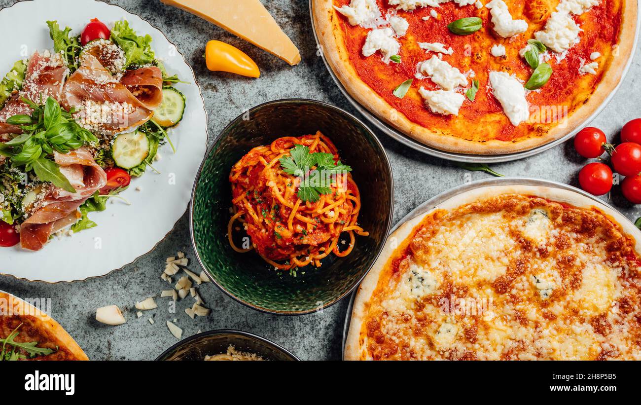 Top view of different types of pizza with pasta and vegetables on a ...