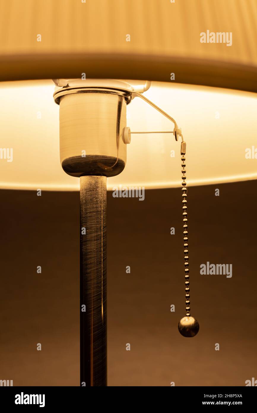 lighted lamp standing in the dark on the background of the wall. High ...