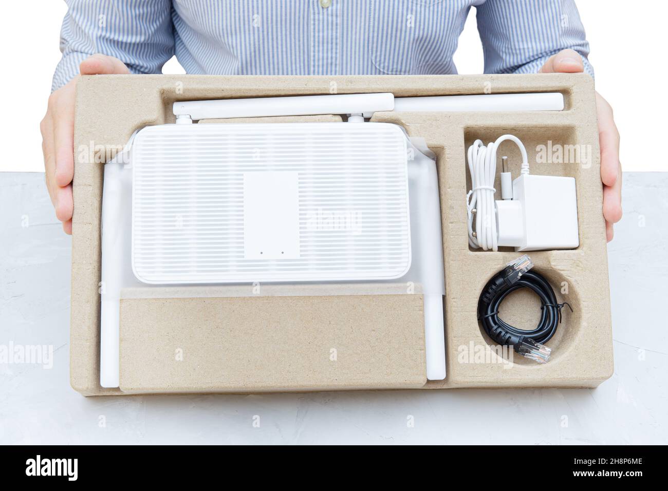 Man wearing a striped shirt shows a dual band Wi-Fi 6 router with ...