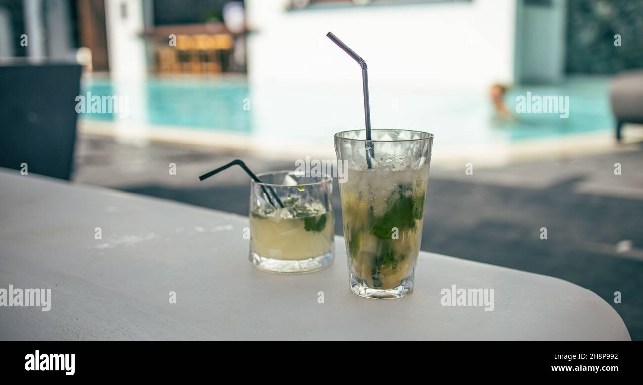 Mojito cocktail at the edge of a resort pool. Concept of luxury ...