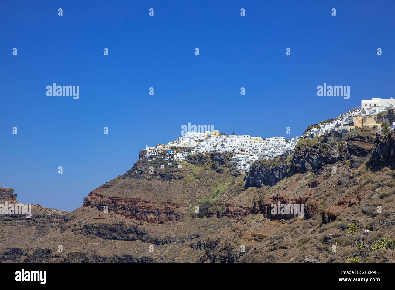 Cliff wall of Santorini island, Greece. Clear blue ocean, sea, with ...