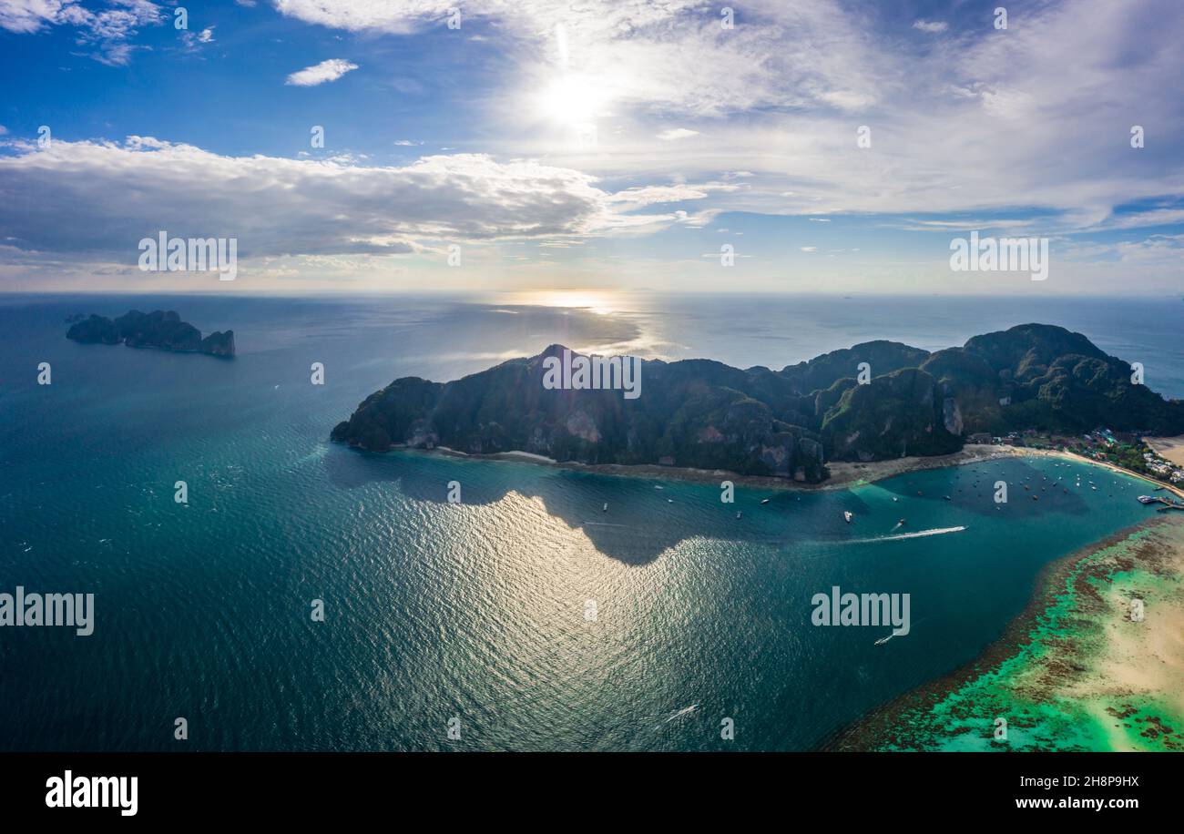 Flying above busy tropical island port filled with boats and ferries ...