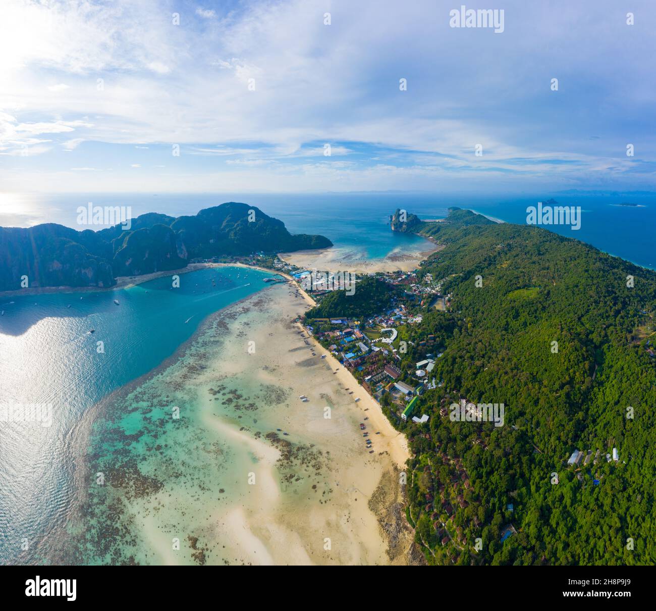Flying above busy tropical island port filled with boats and ferries ...