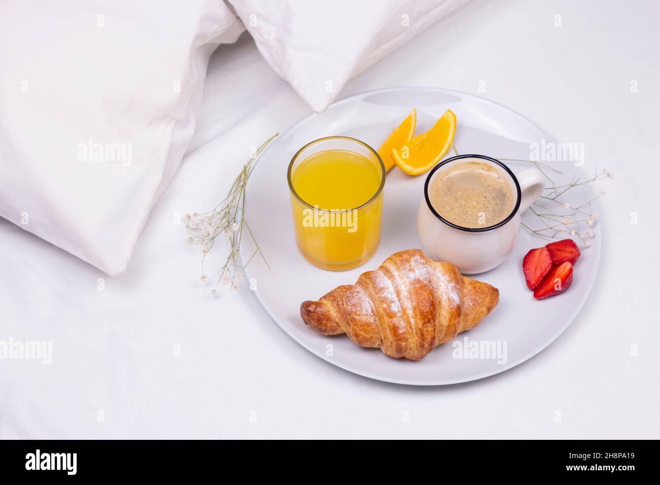 Romantic morning breakfast in bed. Orange juice, croissant and ...