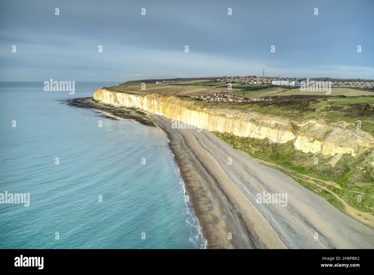 Aerial along Newhaven Beach heading towards the white cliffs of East ...
