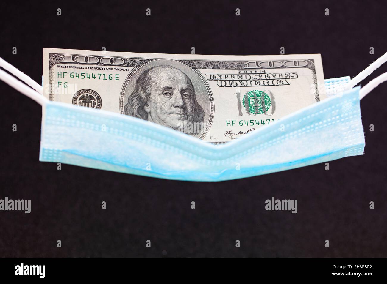 surgical mask as hammock with 100 dollar banknotes Stock Photo - Alamy