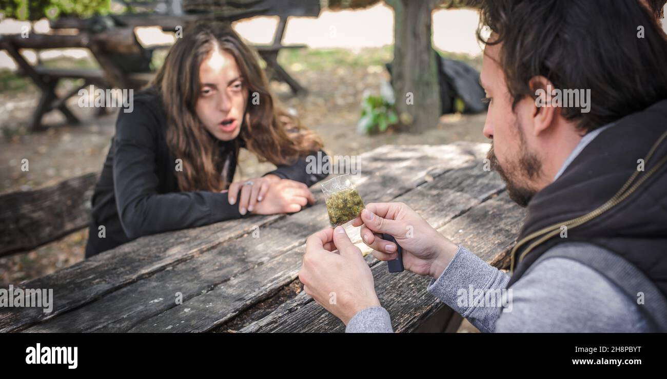 One friend shows the others marijuana weed packet ready to roll ...