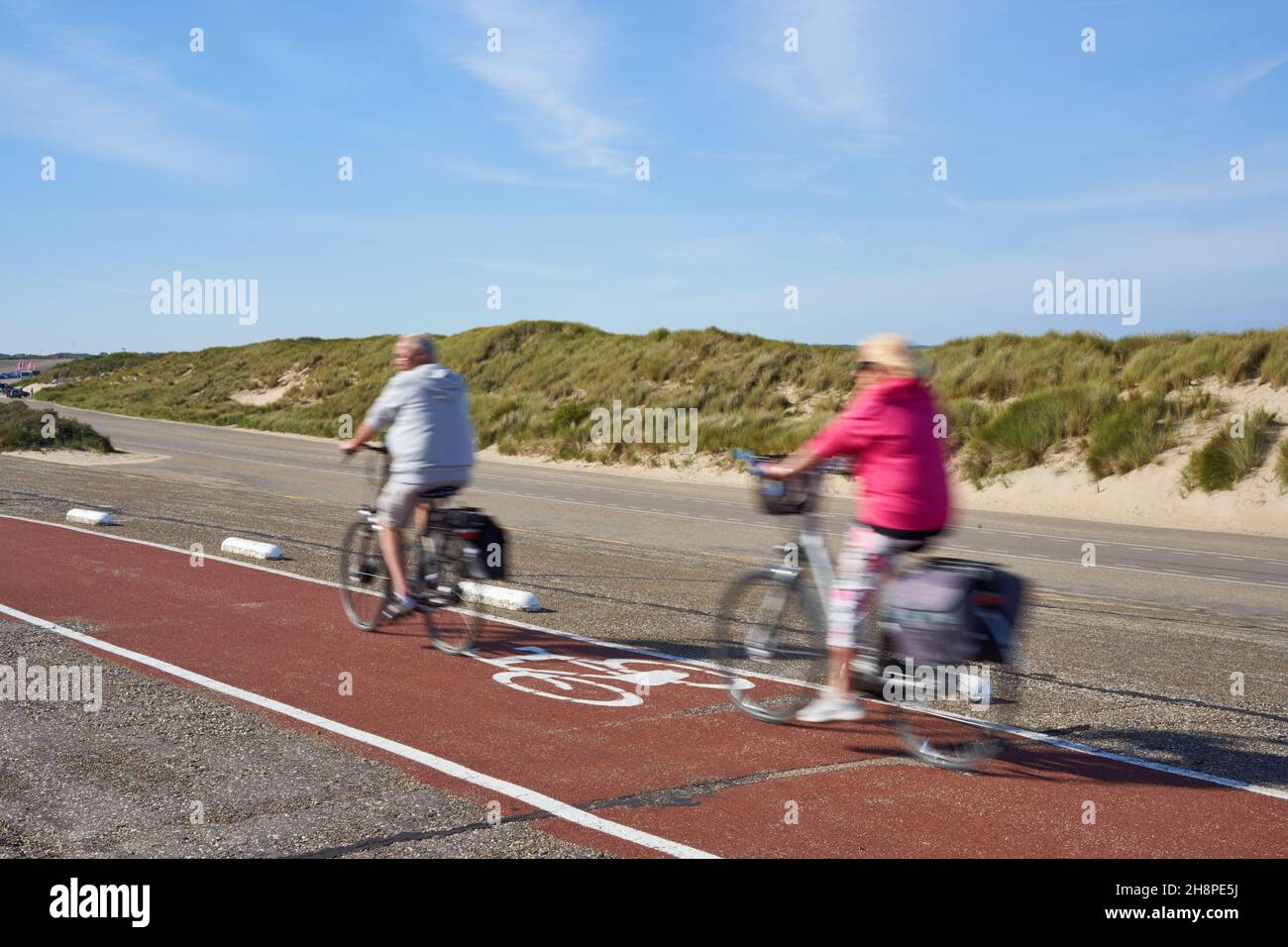 Bike path in the Netherlands. Route on a dam in front of the grass ...