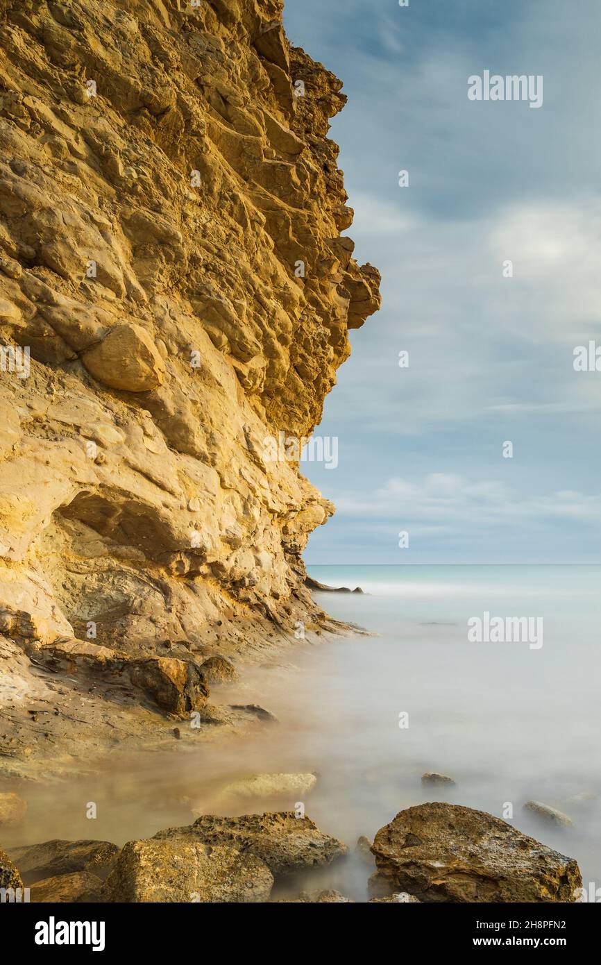 Closeup of a rock coastal cliff against a cloudy sky Stock Photo - Alamy